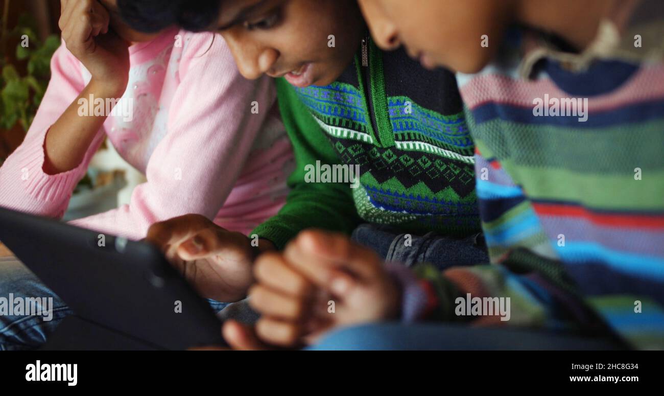 Beautiful shot of South Asian children playing a game with tablet Stock ...