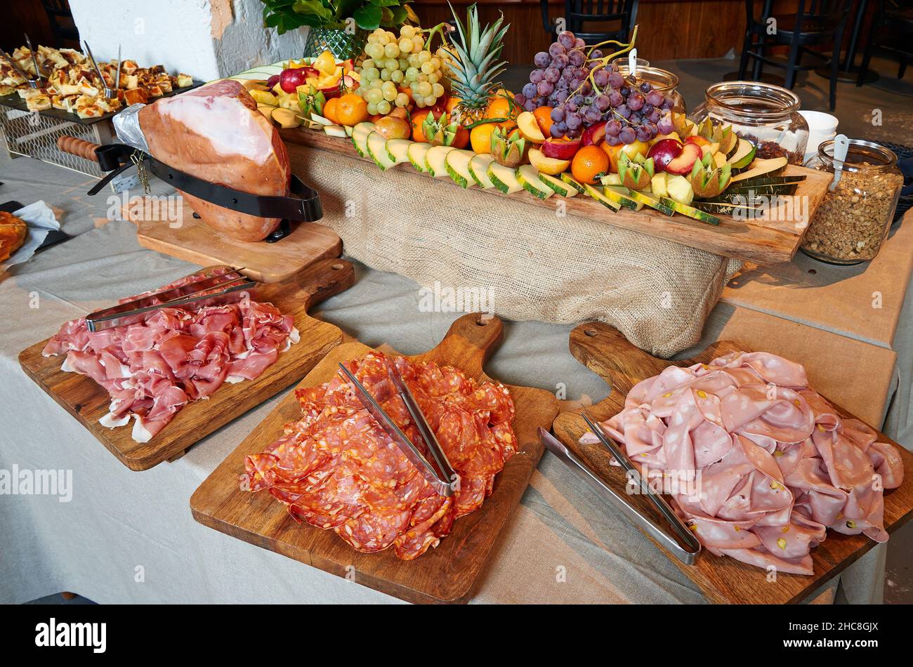 Colored buffet with seasonal fresh fruits and different kind of Ham ...