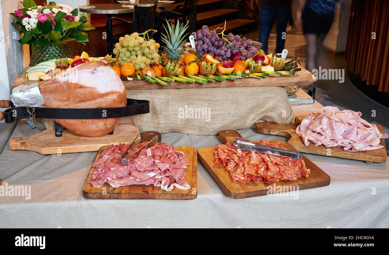 Colored buffet with seasonal fresh fruits and different kind of Ham ...