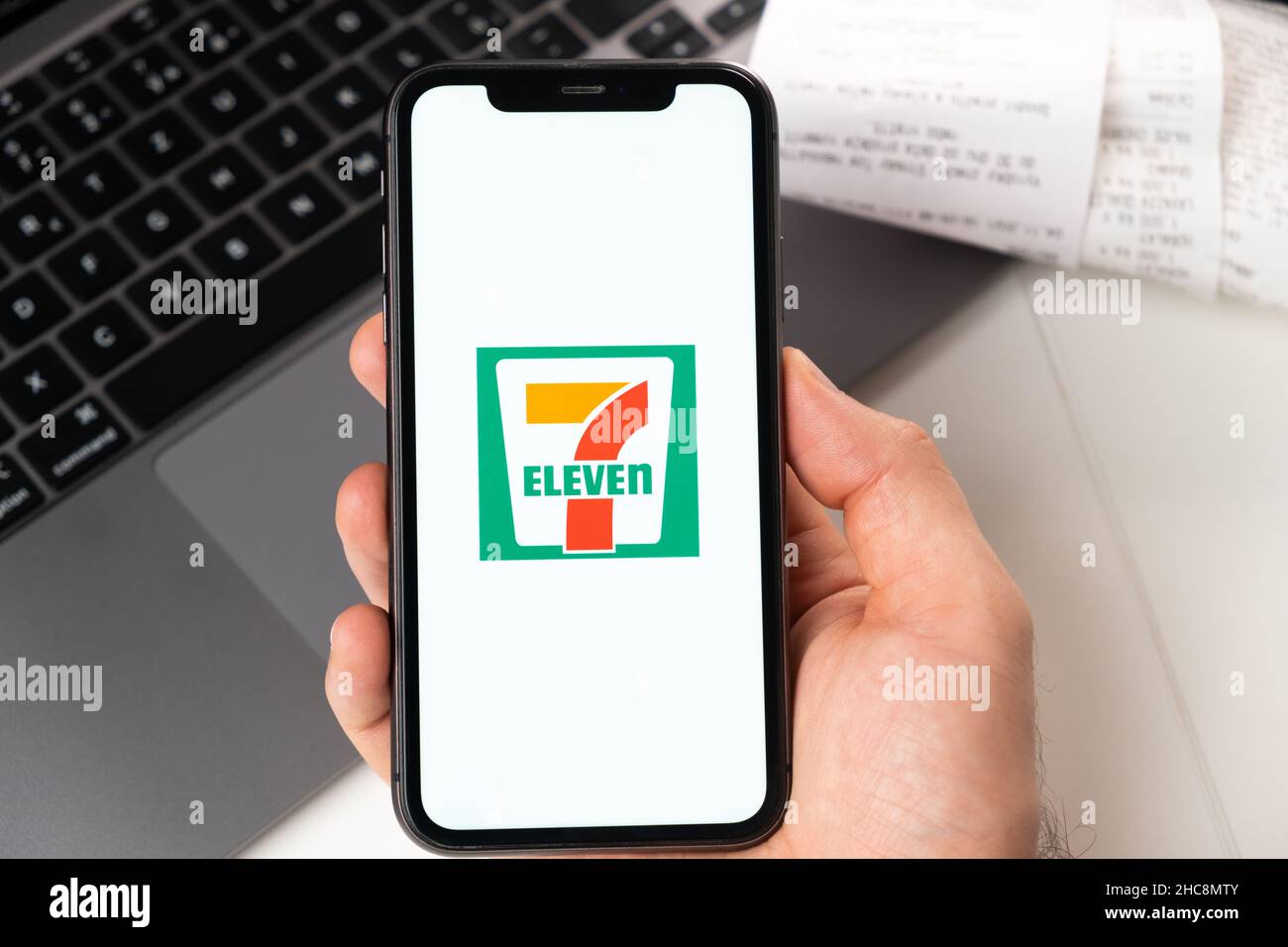 7-Eleven application on the screen of Apple iPhone in mans hand and ...