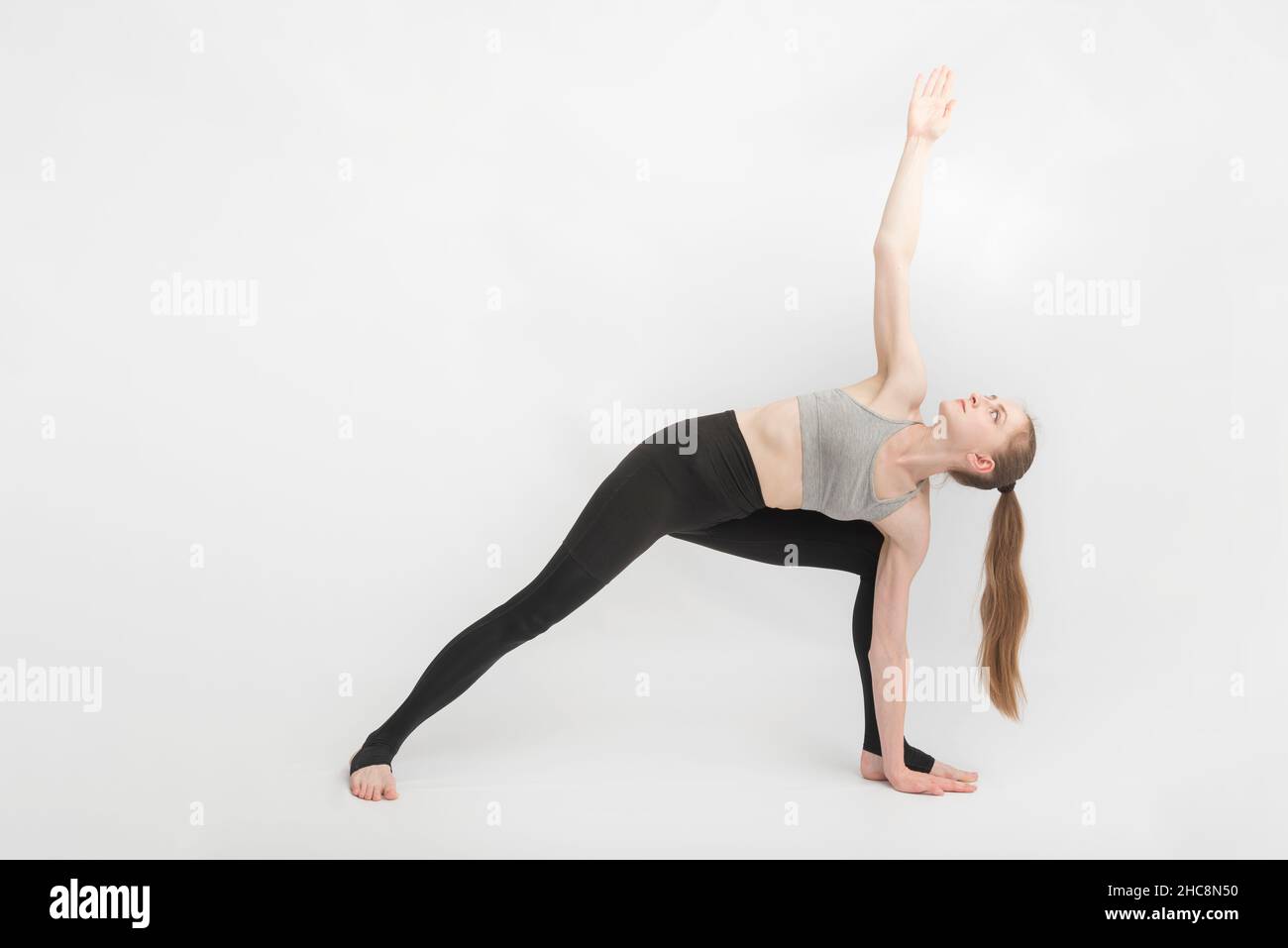 Triangle Pose. Trikonasana. Sports girl does yoga and performs asanas ...