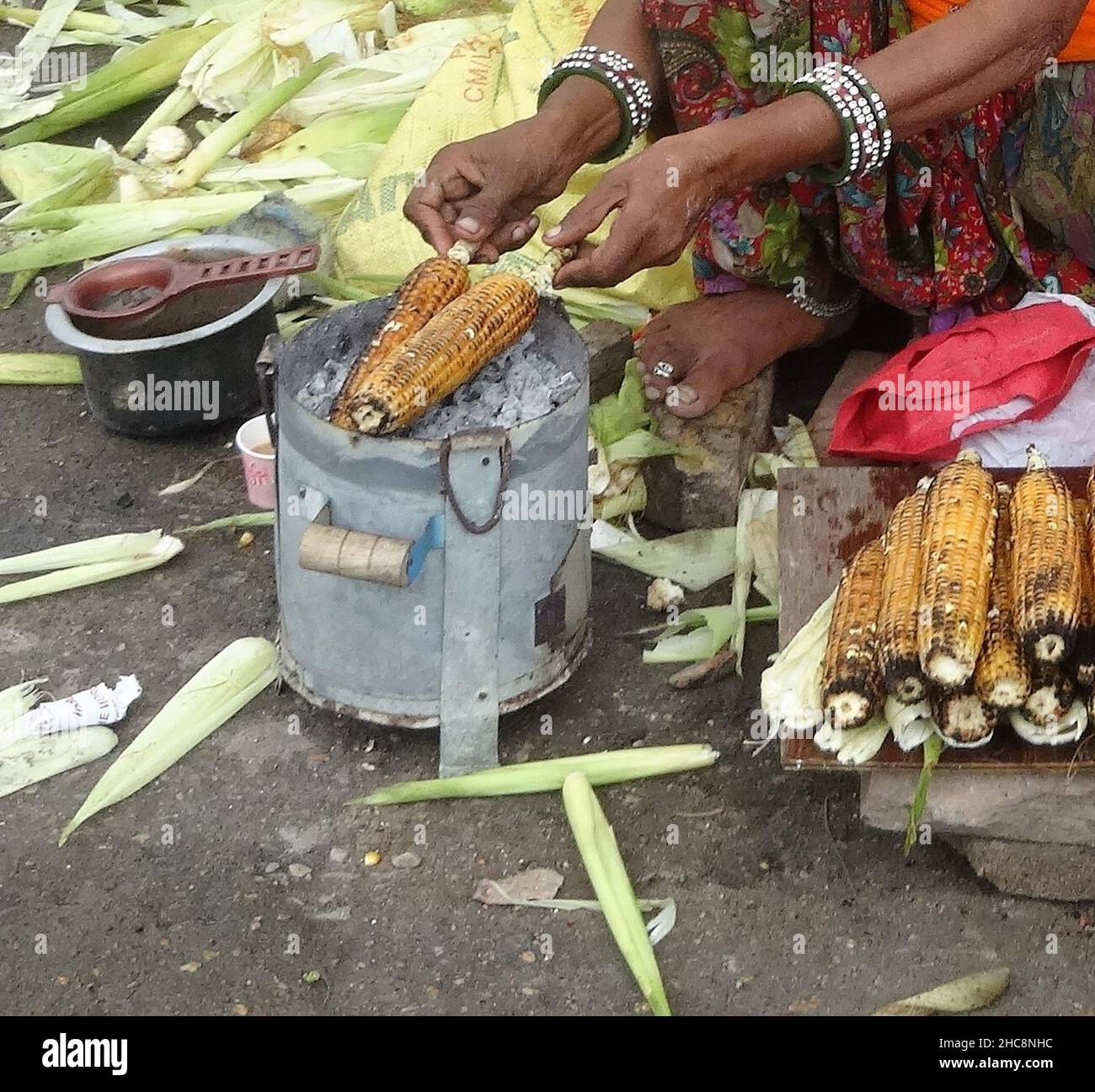A woman making/selling roasted corn on roadside/Jaipur/Rajasthan Stock ...