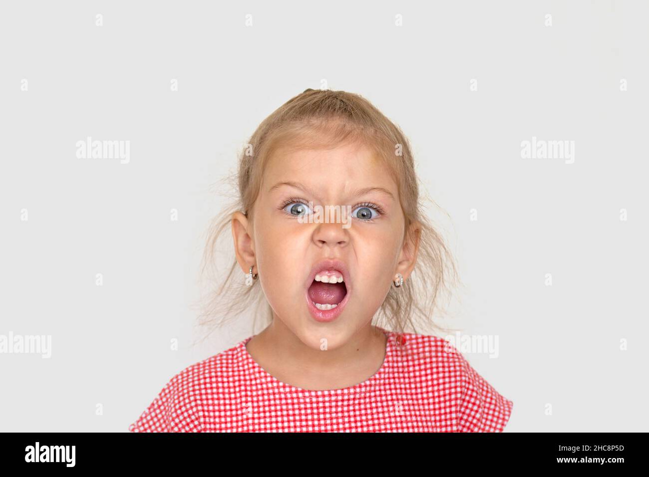 Portrait of funny caucasian little girl of 5 years looking at camera ...