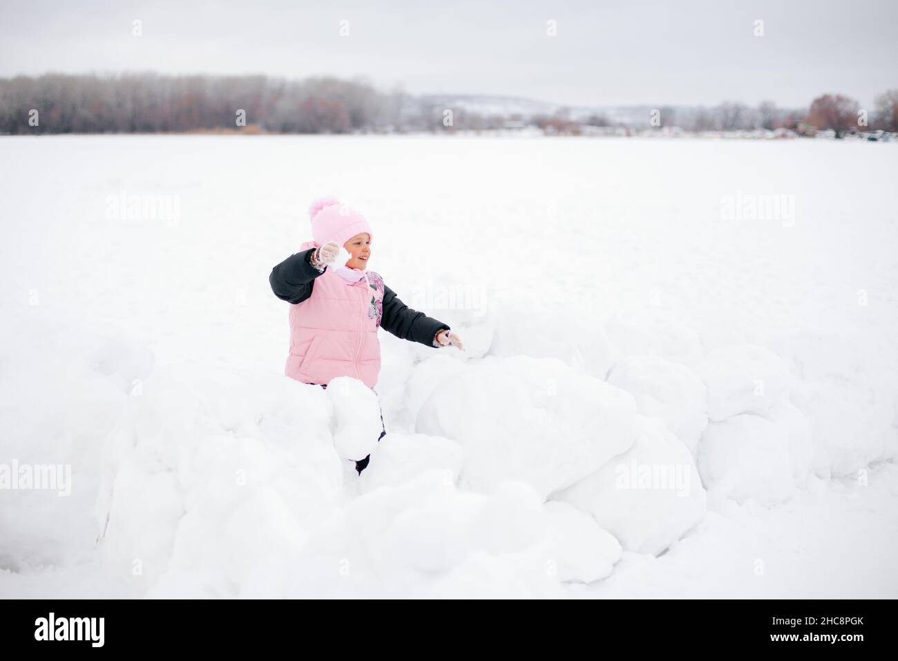 Closeup photo of female kid who is about to throw snowball at someone ...