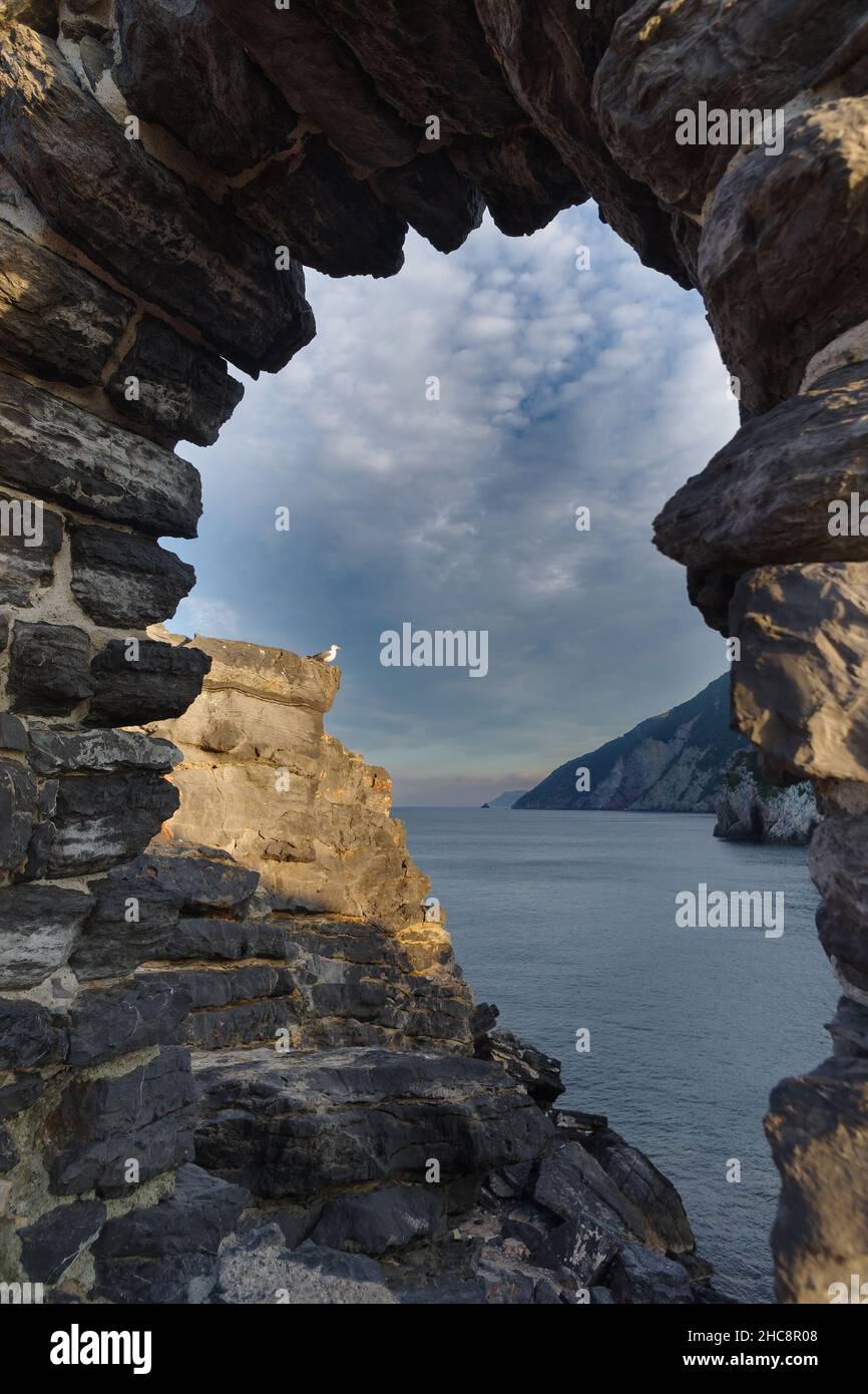 Sea shore seen through stone arch window. Italy, Liguria, Portovenere ...