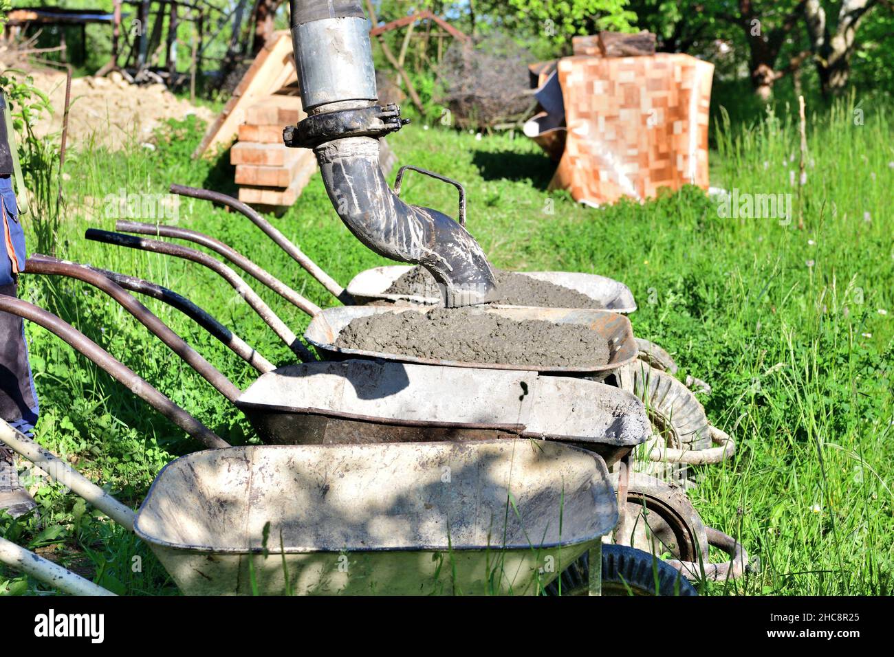 The mason fills the wheelbarrow with concrete from pump machine Stock ...