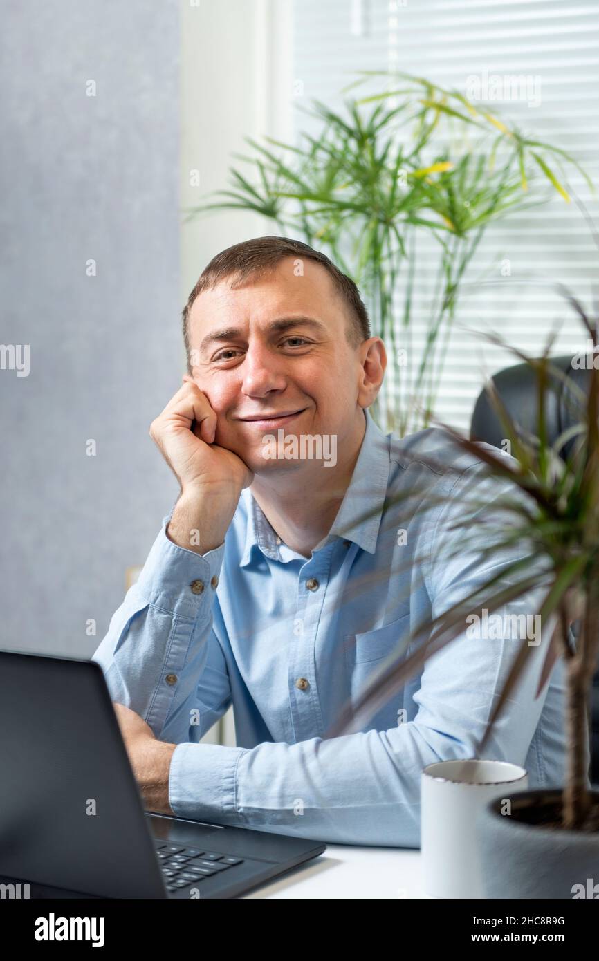Cheerful good-natured man at his workplace. Friendly boss. Portrait of ...