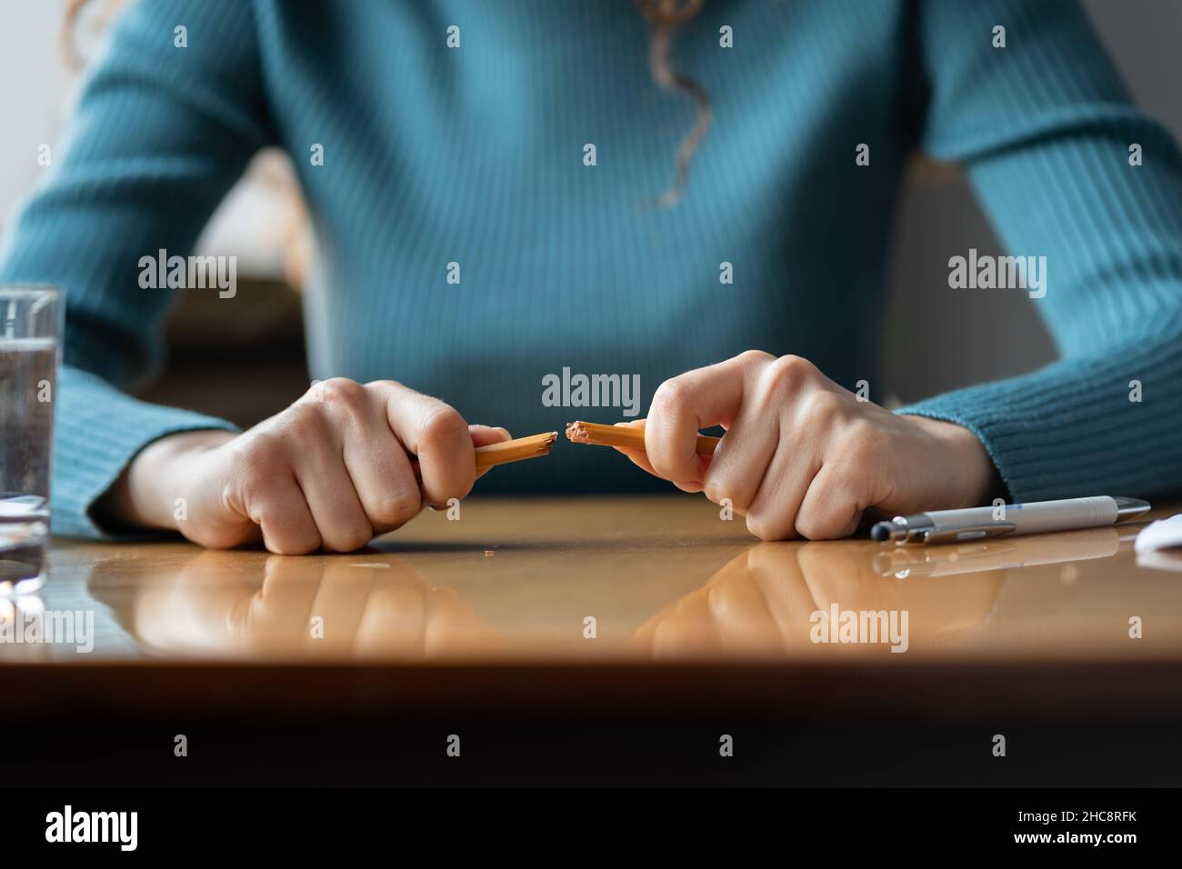 Outraged employee breaking pencil at workplace. Angry businesswoman ...