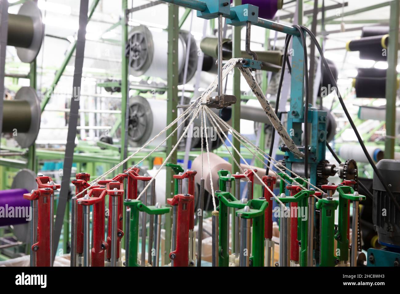 Narrow warp beams on the loom. Textile industry. Spinning spool on a ...