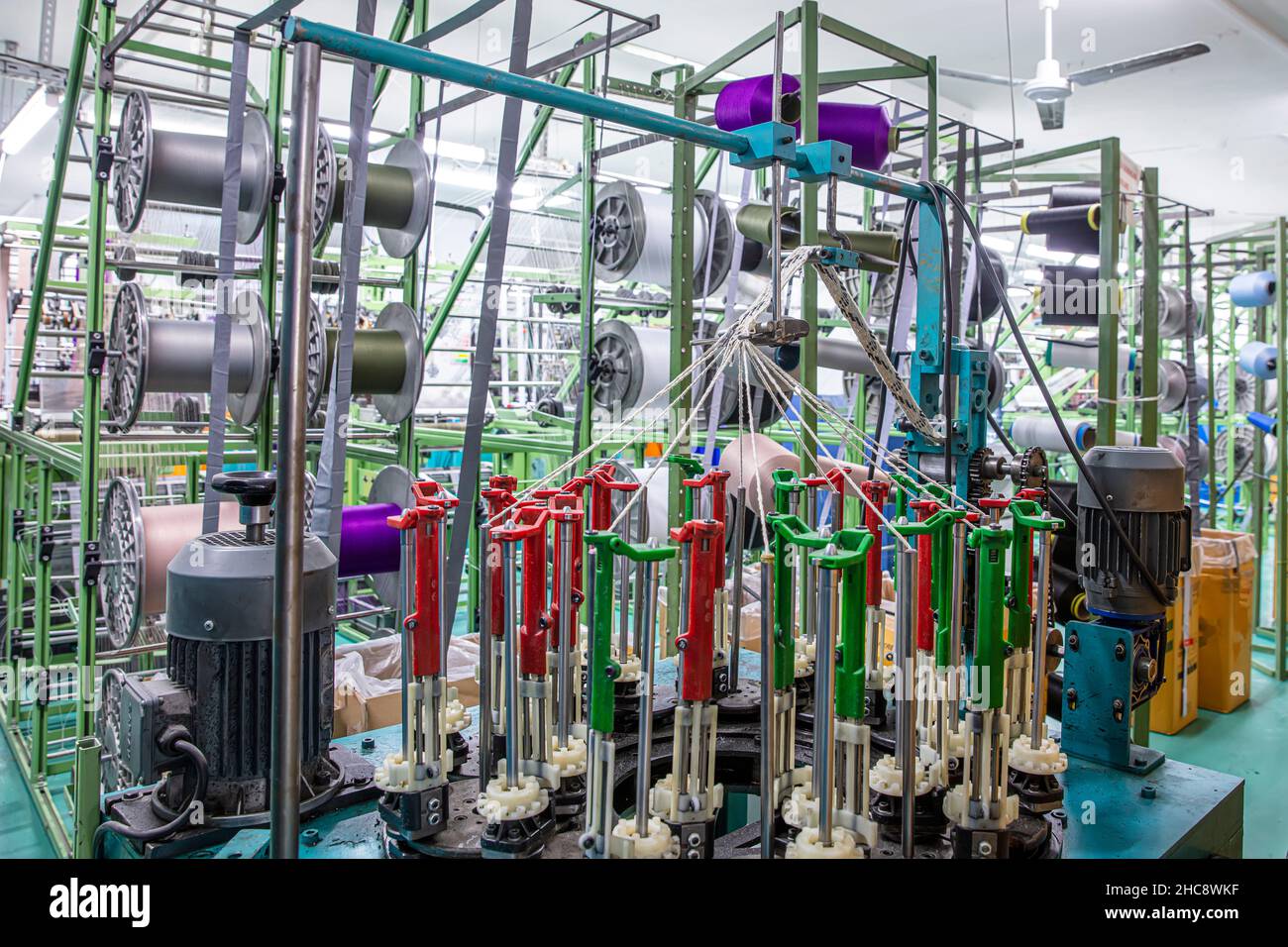 Narrow warp beams on the loom. Textile industry. Spinning spool on a ...
