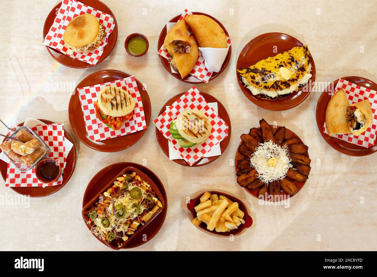 Table with Latin American food, Venezuelan Arepas, empanadas, platano ...