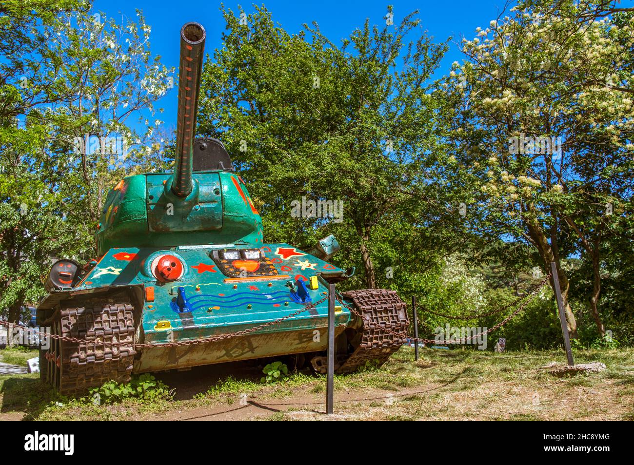Old military tank painted in colorful hearts, stars, and flowers in a ...