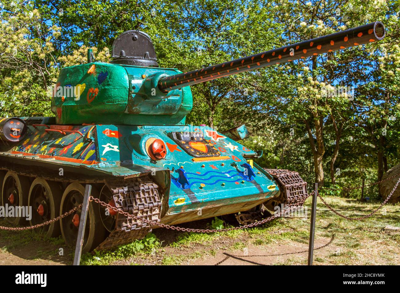 Old military tank painted in colorful hearts, stars, and flowers in a ...