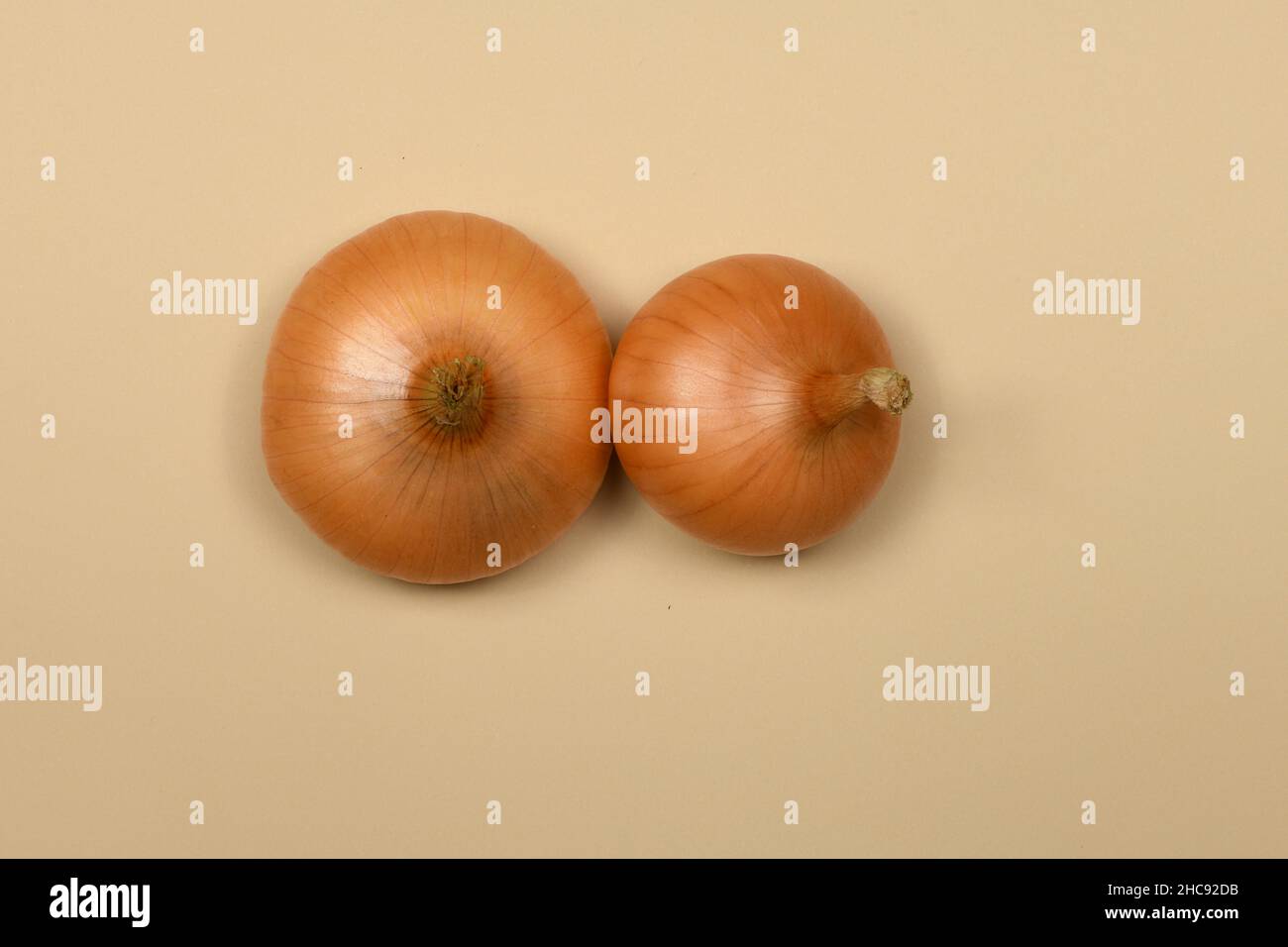 Yellow onion bulbs on beige background. High resolution photo. Full ...