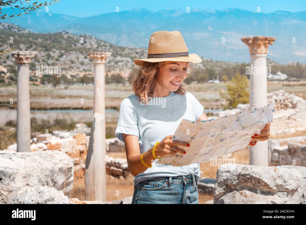 Traveler girl reading map at the ancient ruins of antique Greek city of ...