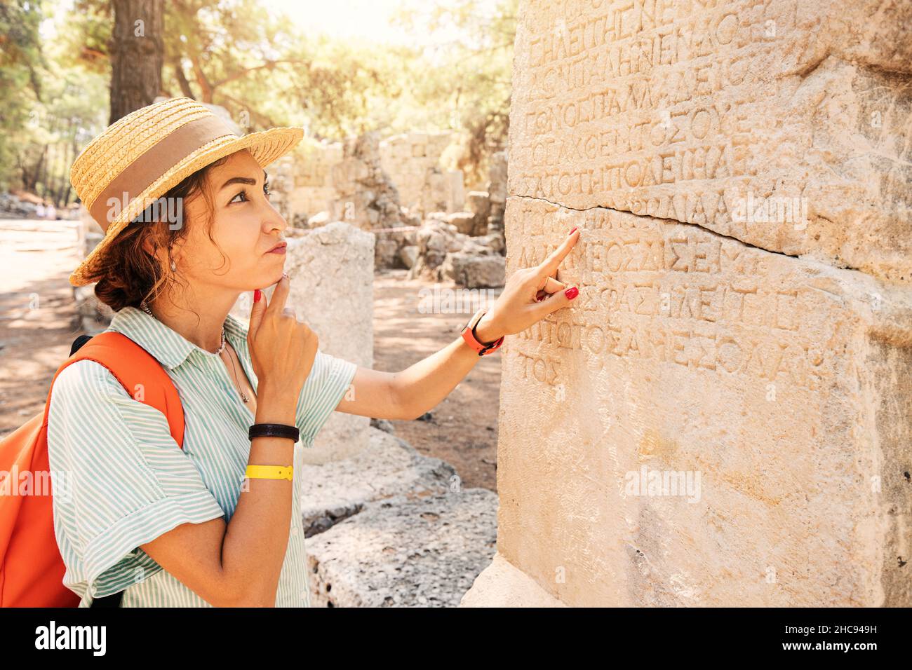 Woman philologist and tourist reads and tries to translate ancient ...