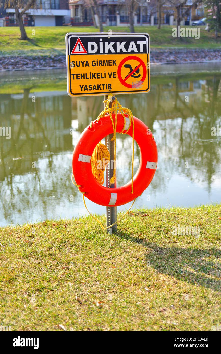 Life Buoy and Warning sign at riverside in a sunny day in Turkey Stock ...