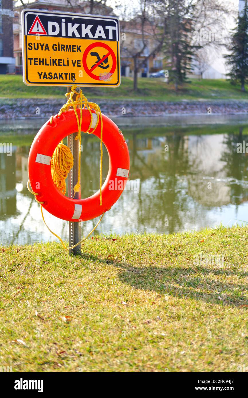 Life Buoy and Warning sign at riverside in a sunny day in Turkey Stock ...