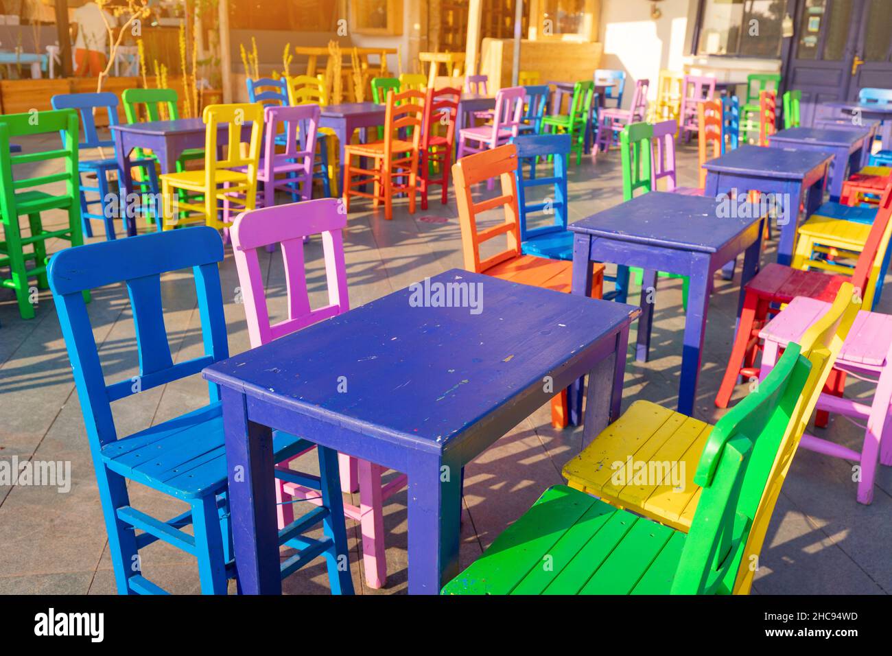 Cute colorful wooden tables and chairs in the outdoor cafe at the ...
