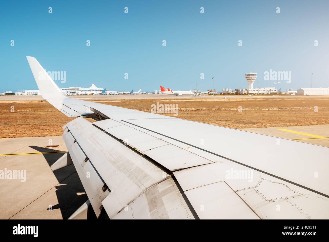 The wing of a passenger plane and the control tower at the airport ...