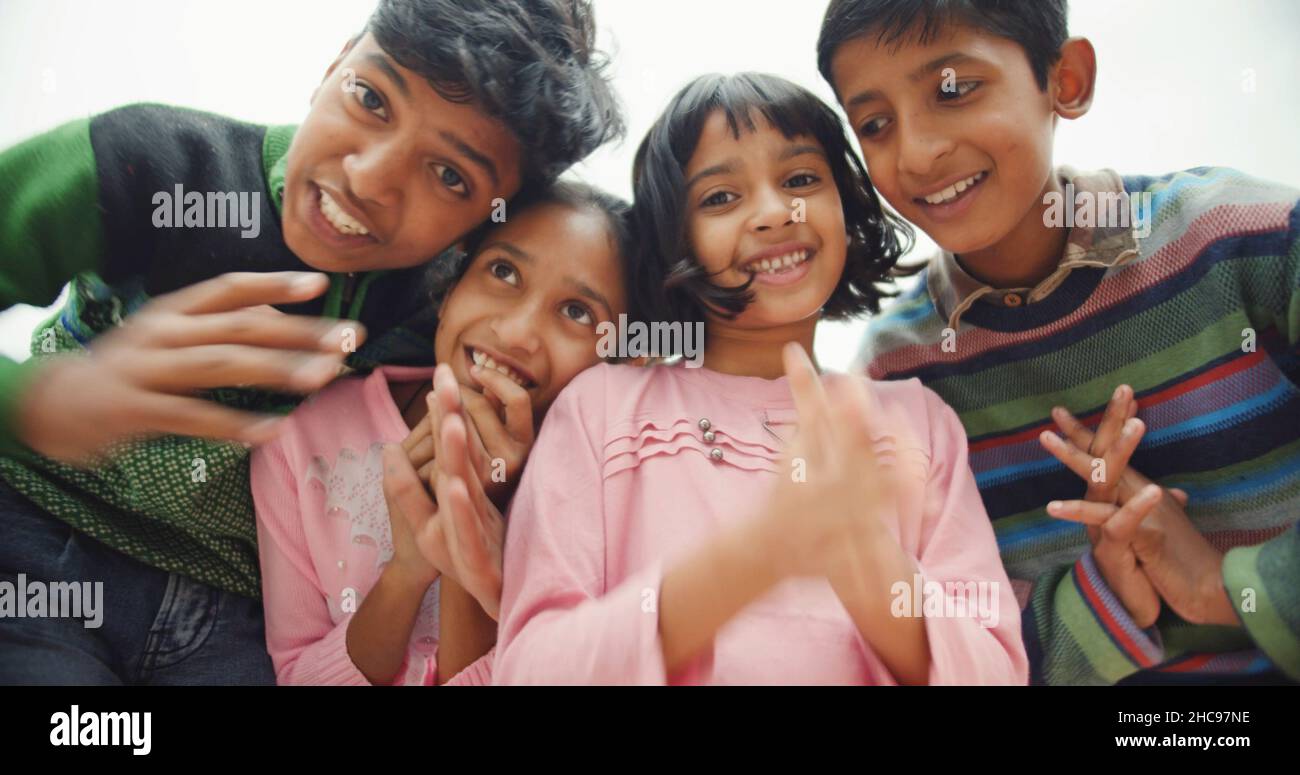 Low angle shot of two Indian male and two Indian female kids smiling ...