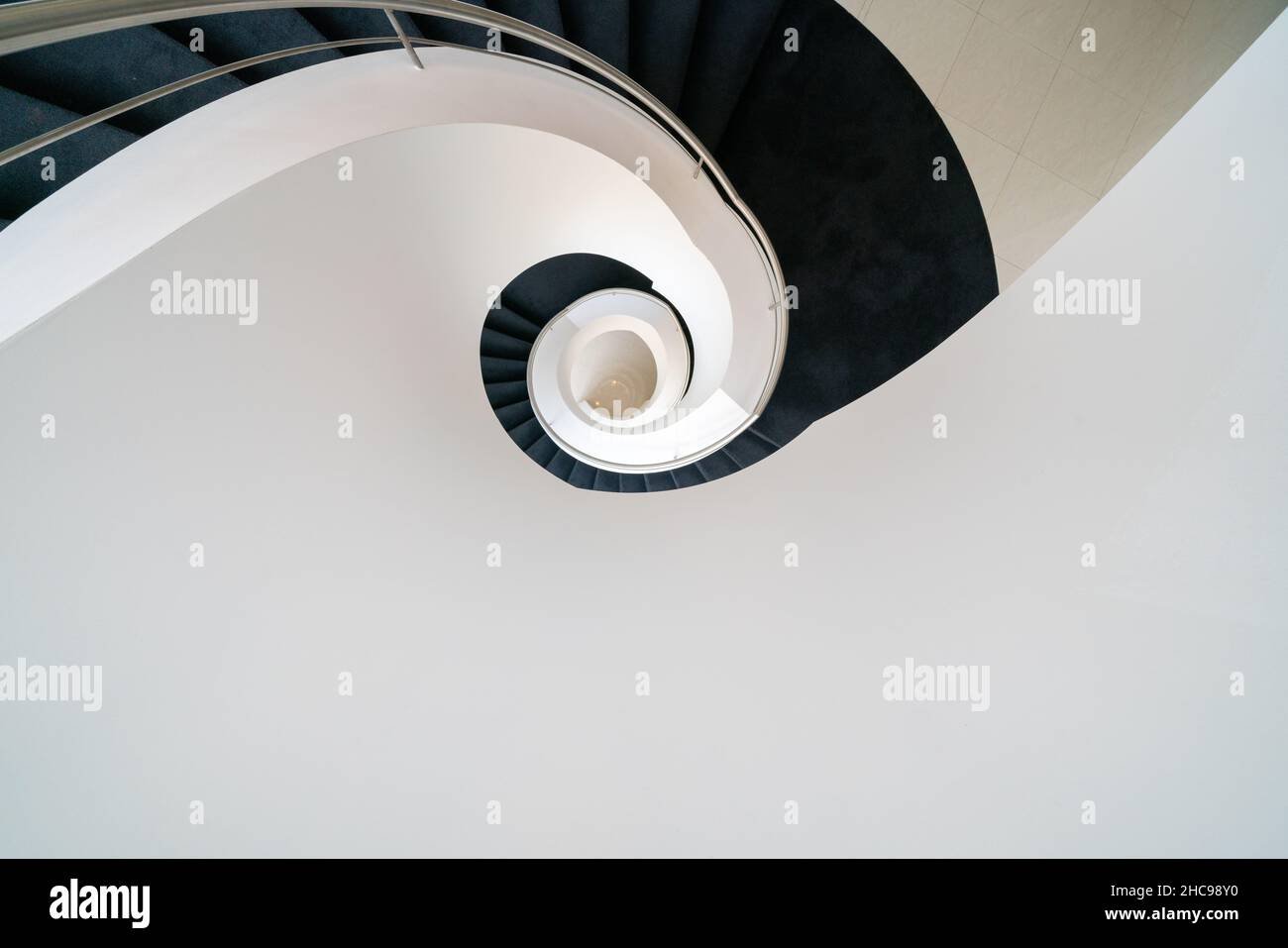 Top view of black deep modern spiral staircase with white railings ...