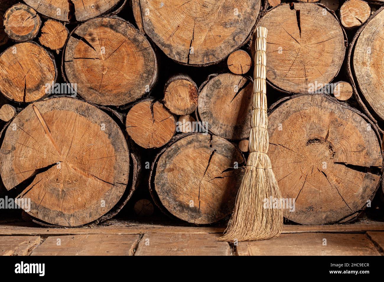 A broom stands against a wall made of sawn trees Stock Photo - Alamy