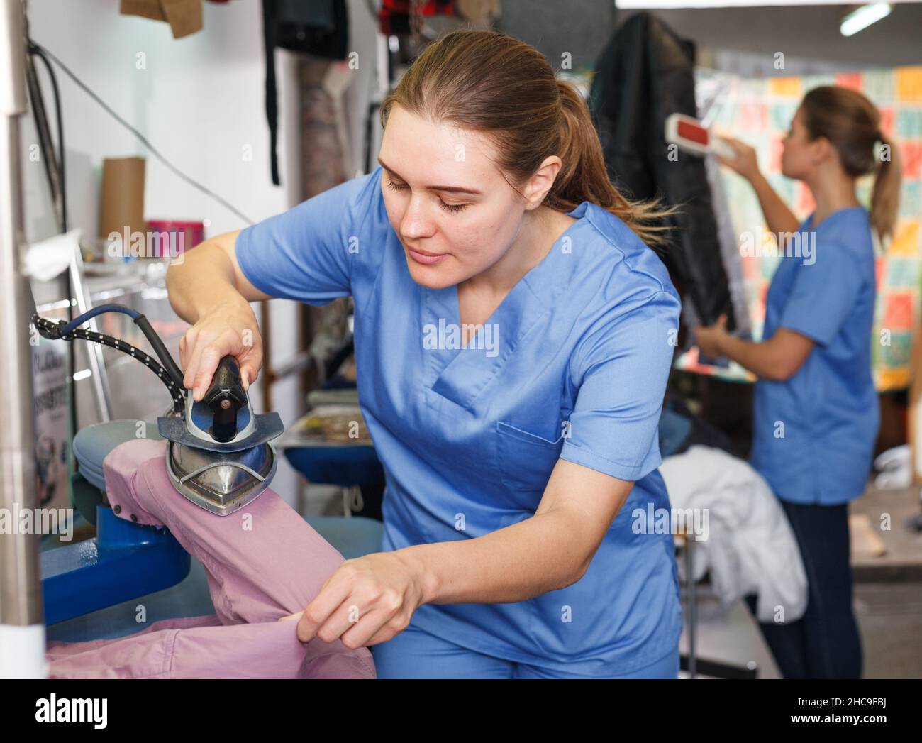 Female laundry worker ironing hi-res stock photography and images - Alamy
