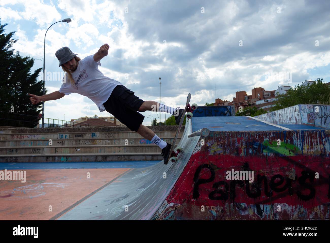 young blond boy performing skateboarding tricks jumping in the ...