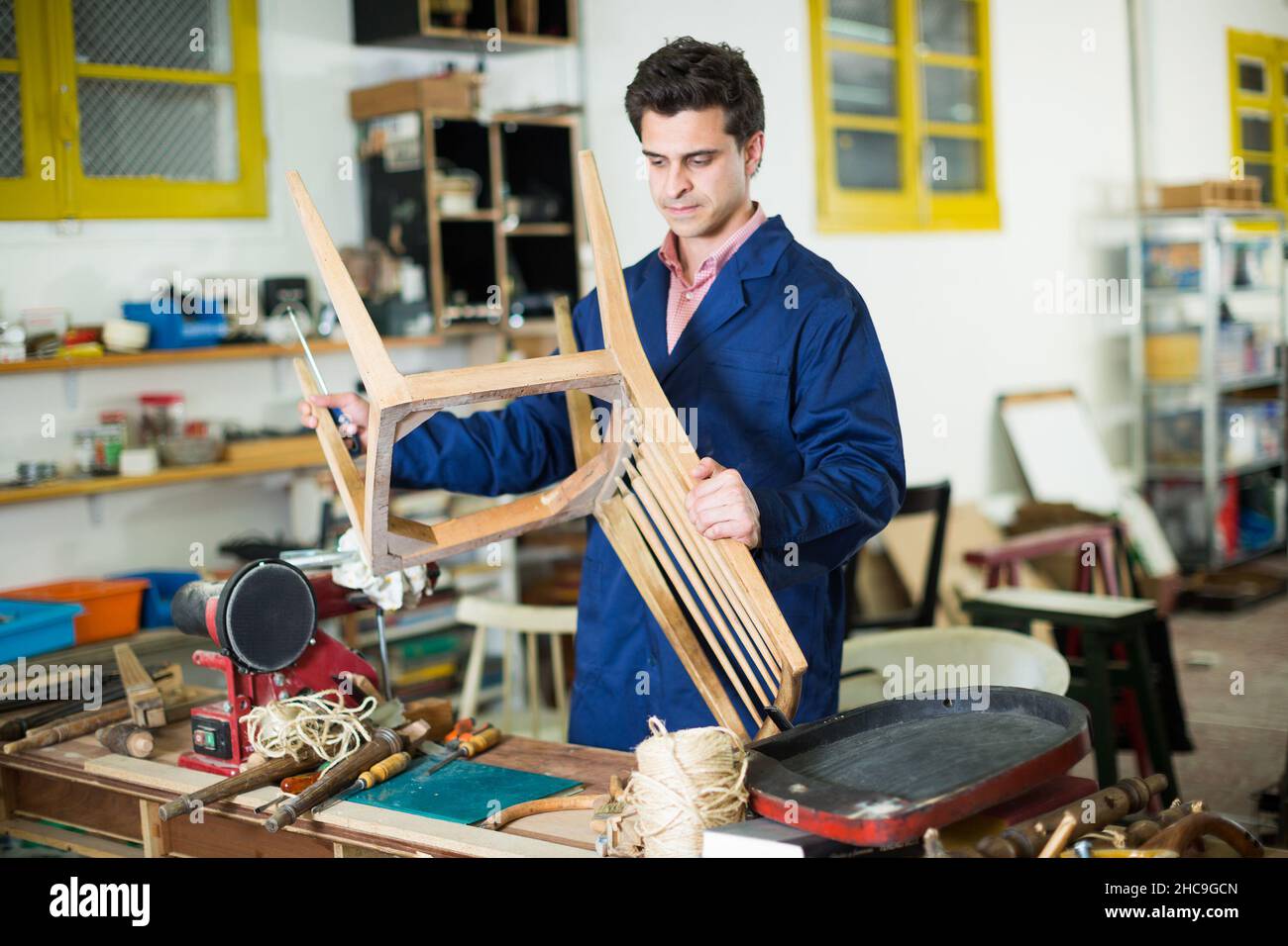 Man carpenter in furniture repair workshop Stock Photo - Alamy