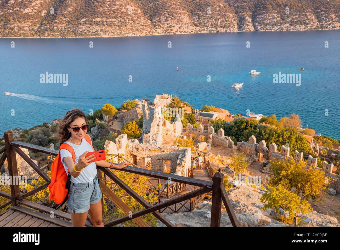 Tourist girl taking photos on smartphone of the scenic Kekova island ...