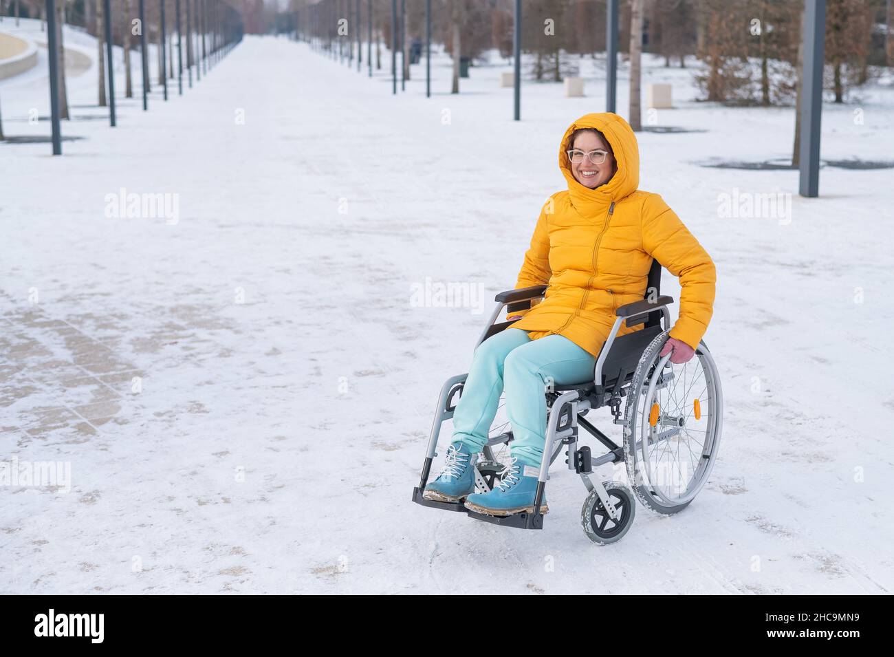 Caucasian woman with disabilities rides on a chair in the park in ...