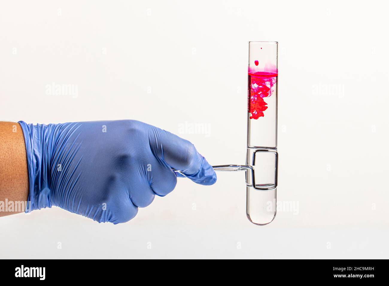 Test tube with red reagent and pipette close-up. Colored liquid in test ...