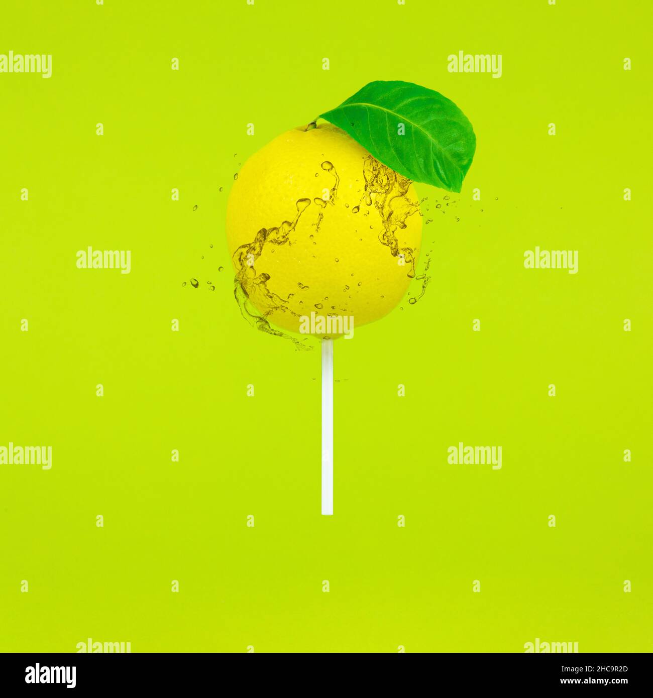 Lemon lollipop with stick and splash on light green background. Candy ...