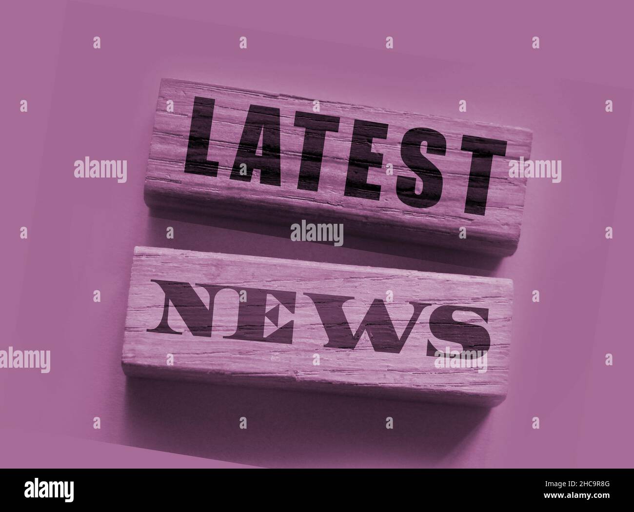 Latest News words on a wooden blocks on yellow and magenta background ...