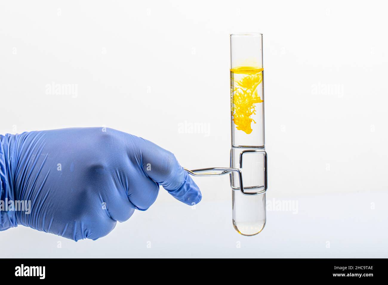 Test tube with yellow reagent and pipette close-up. Colored liquid in ...