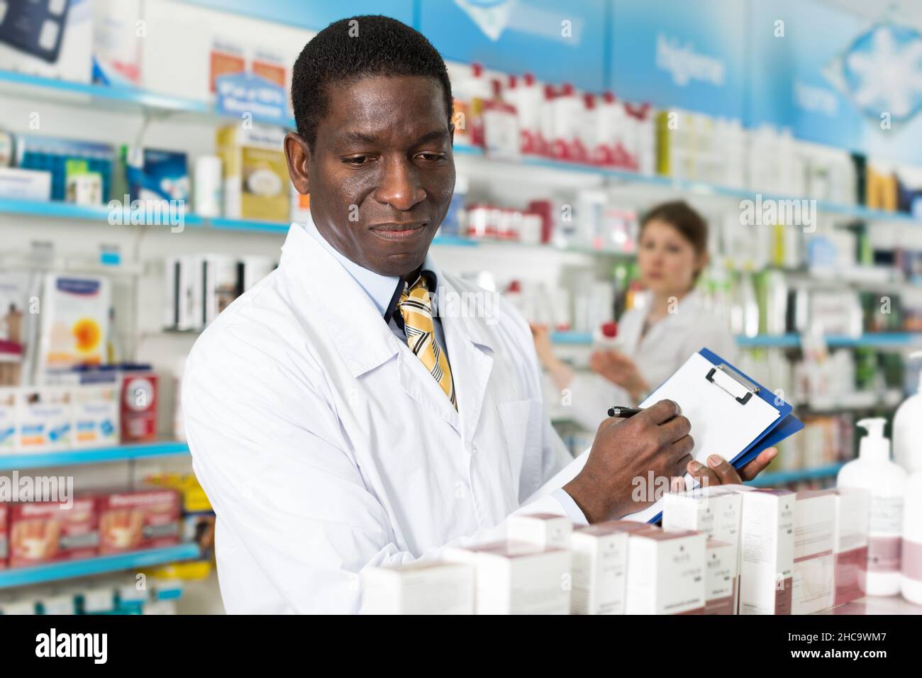 African American man pharmacy chemist making notes on clipboard Stock ...