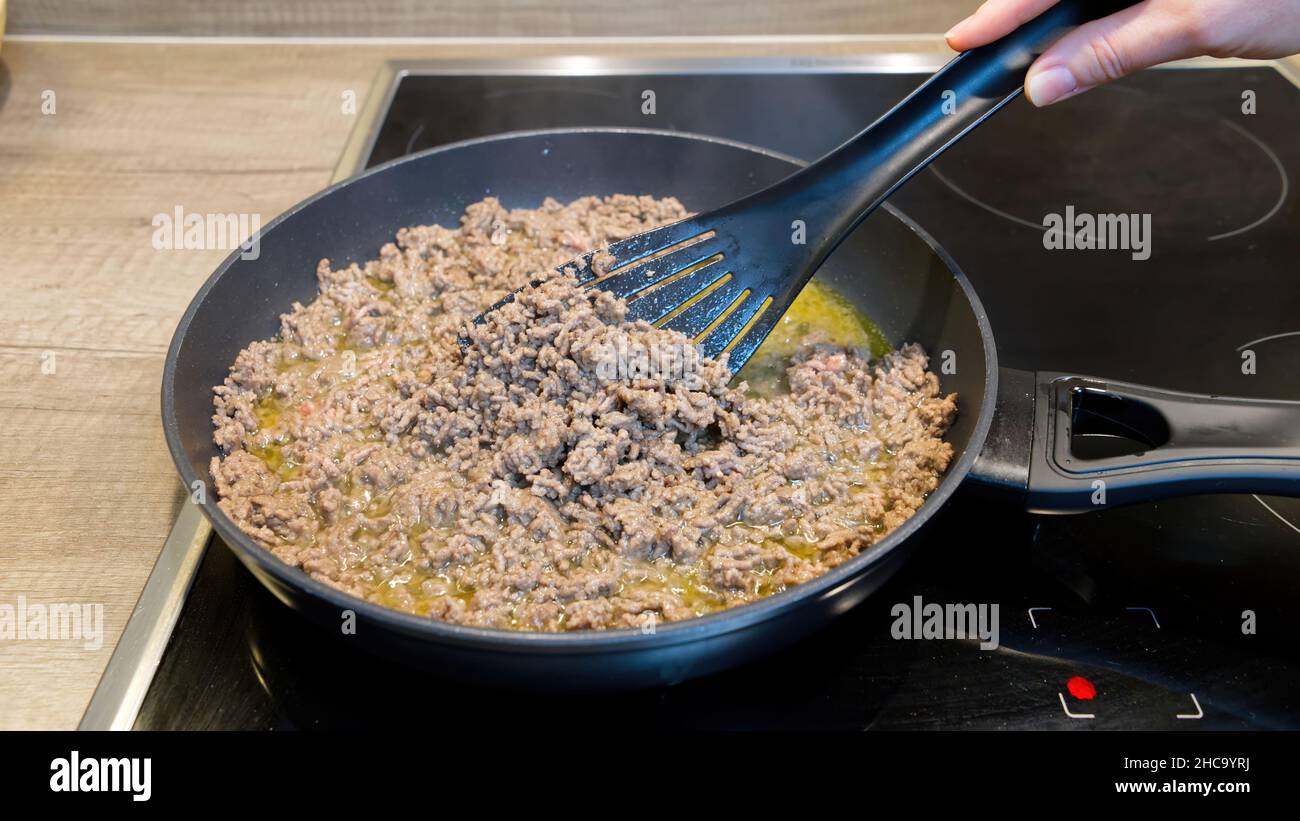 Chef frying minced meat in a pan Stock Photo - Alamy