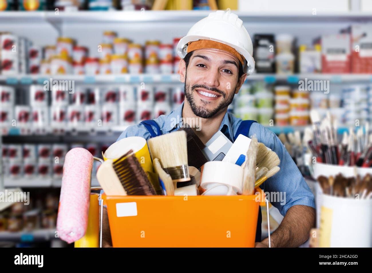 Smiling workman with tools in hands with purchases Stock Photo - Alamy