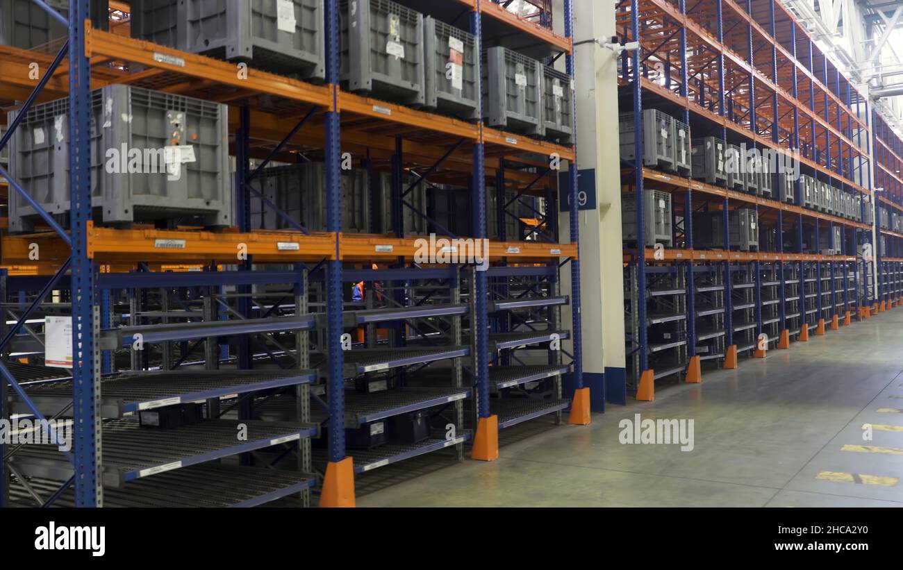 Large and spacious warehouse with many plastic boxes on the shelves ...