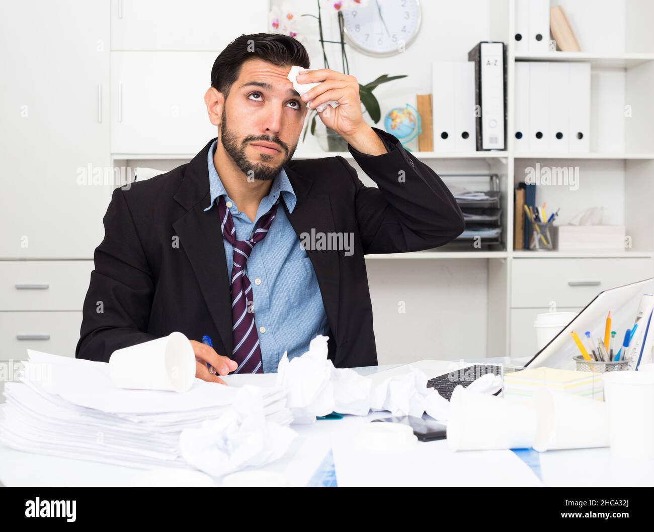 Adult businessman is sad because he is having issues at work place ...