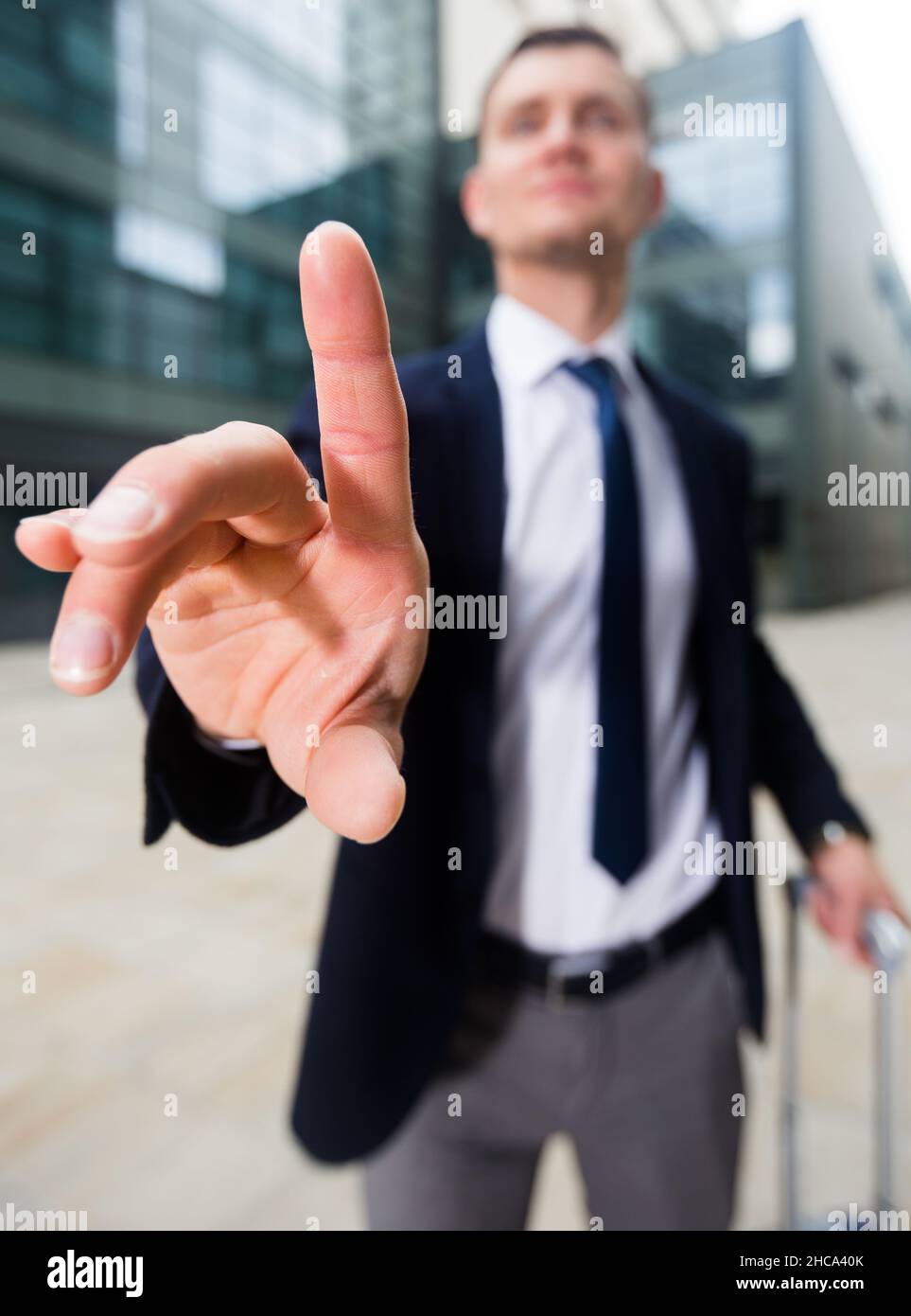 Office manager with suitcase asking companion to wait Stock Photo - Alamy