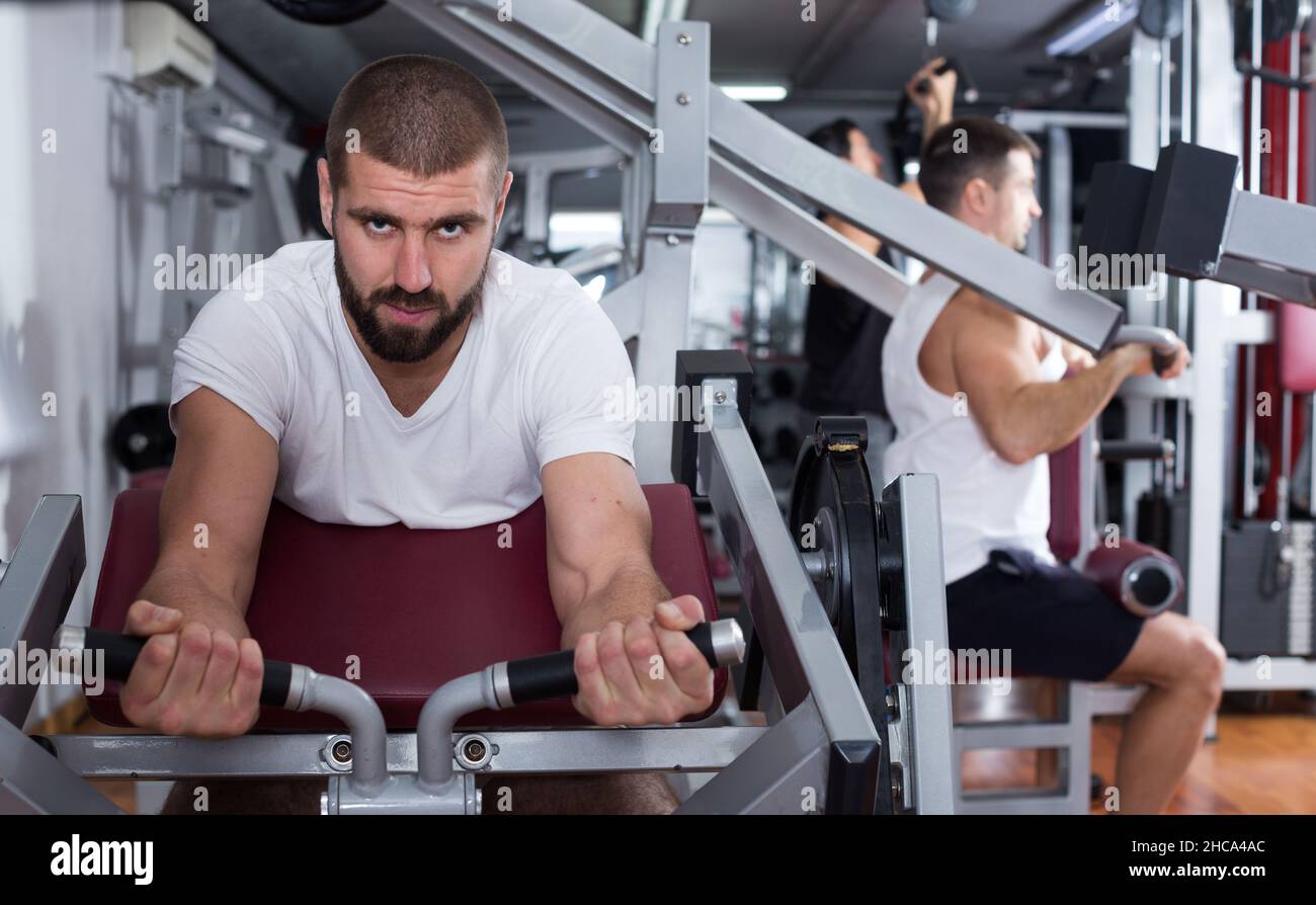 Man training on fitness machine in gym Stock Photo - Alamy