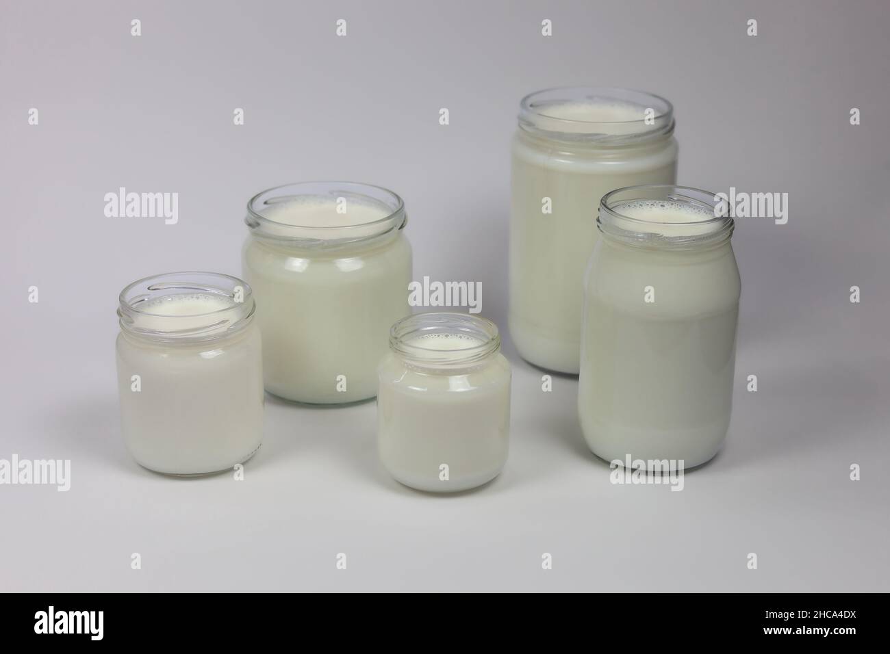 milk bottles in the jar on white background Stock Photo - Alamy