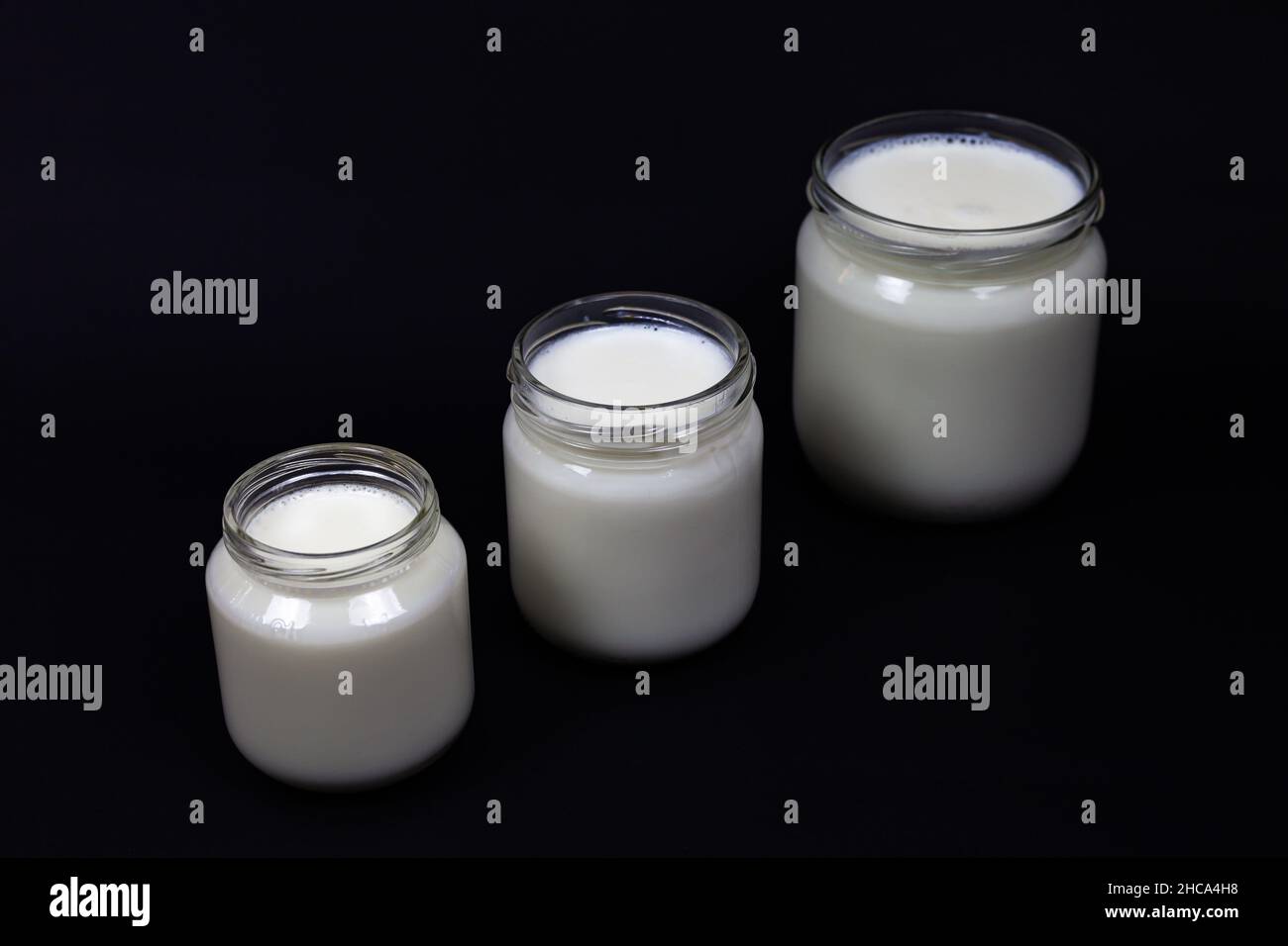 Fresh milk in jar on black background Stock Photo - Alamy