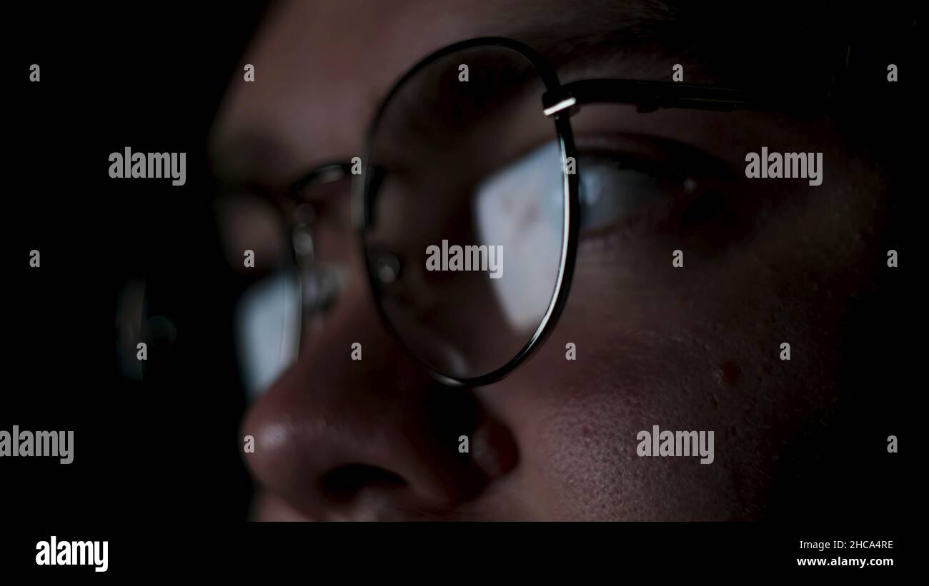 Glasses with reflected computer screen in lenses. Close up of thoughtful business man face or ...