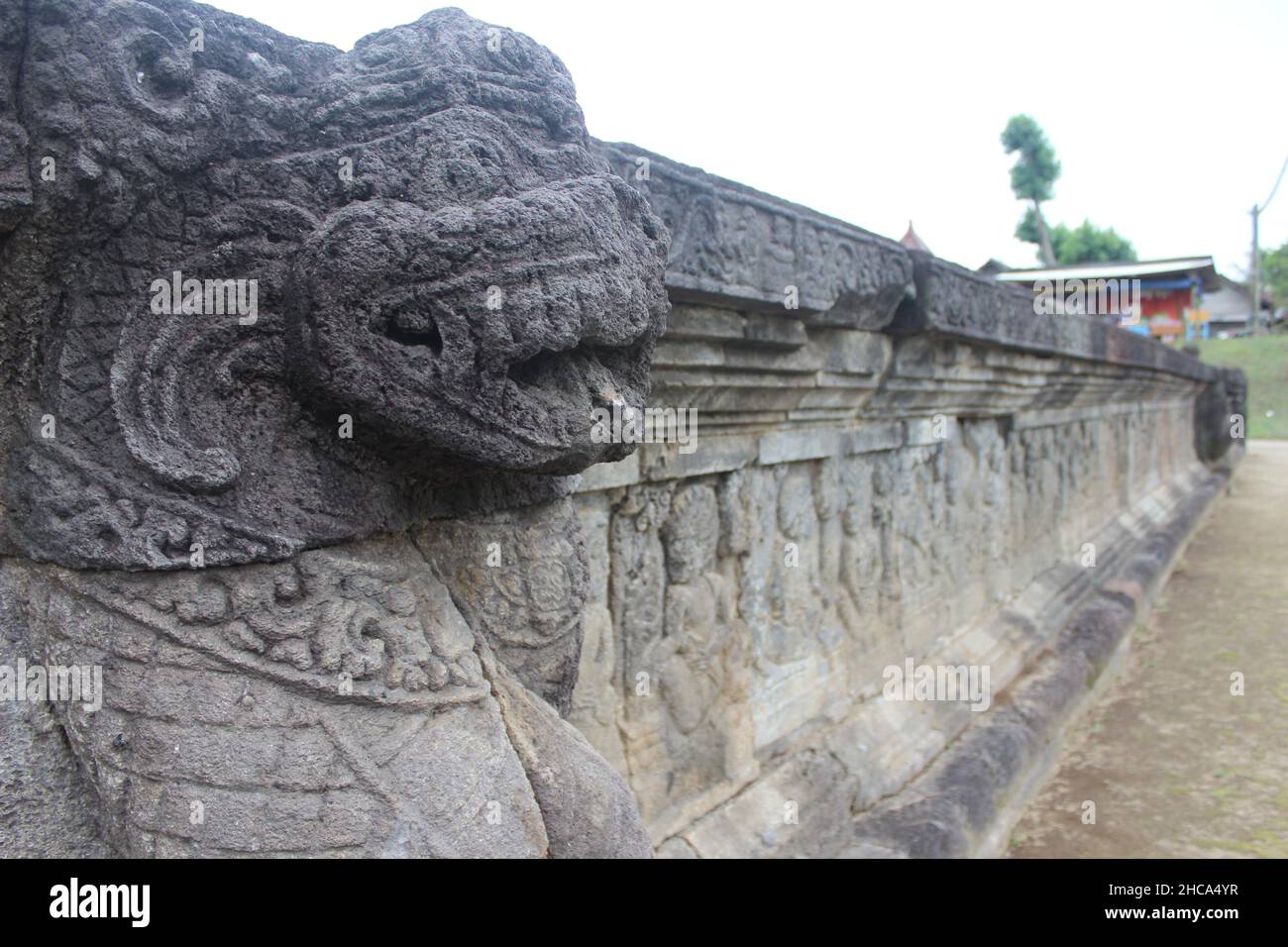 reliefs of traditional statues and buildings at the Penataran Temple in ...