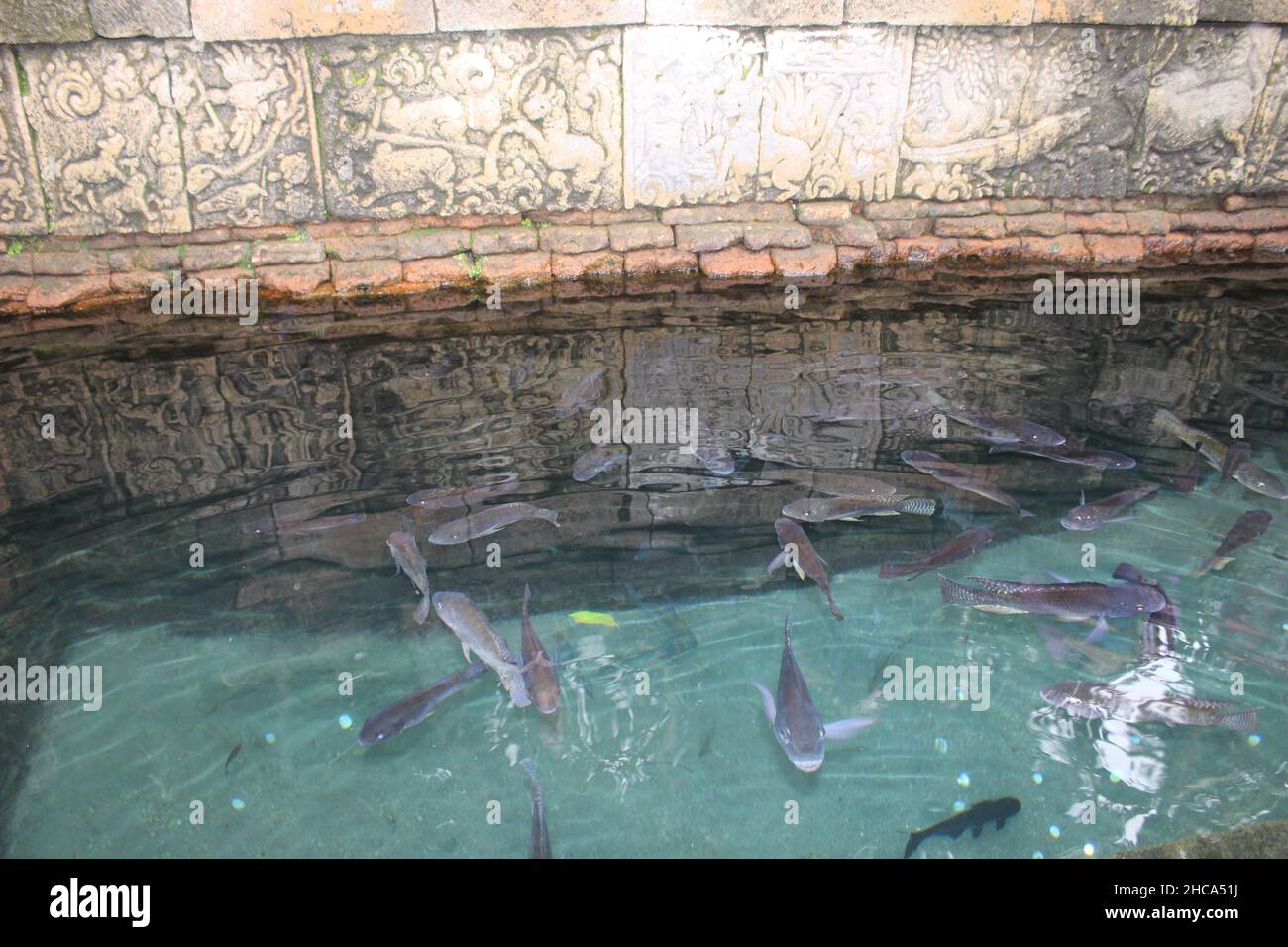 reliefs of traditional statues and buildings at the Penataran Temple in ...