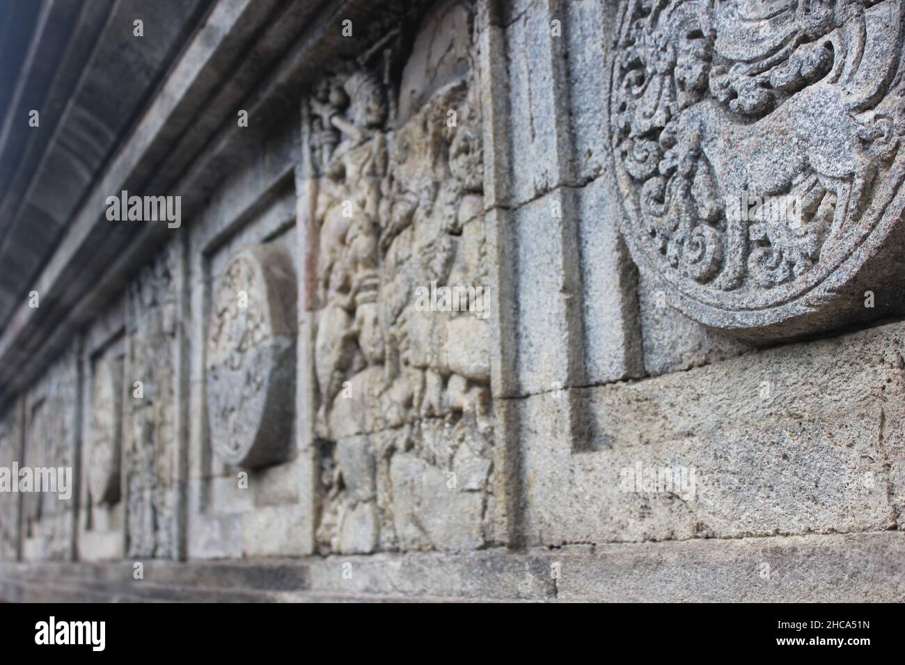 reliefs of traditional statues and buildings at the Penataran Temple in ...