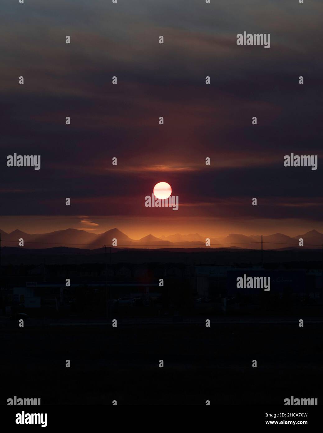 Vertical shot of the sun glowing in the dark sky. Sunset in Calgary ...